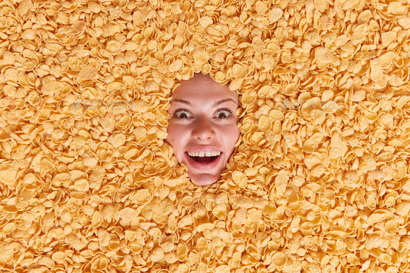 Overhead shot of surprised cheerful young woman sticks head through dry ...