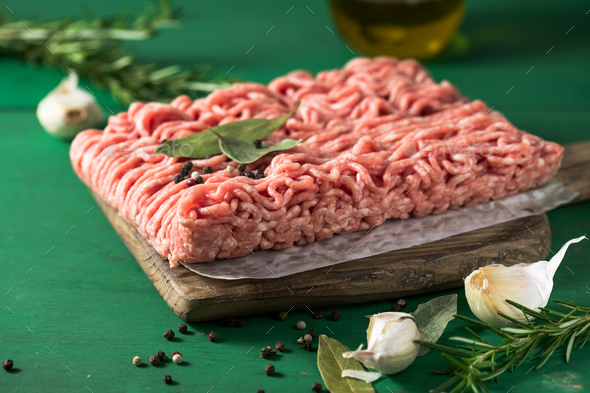 Raw Mince, minced Ground beef meat on a cutting board. Green background ...