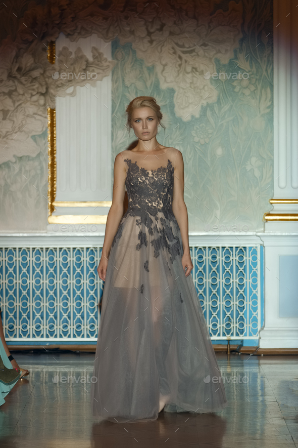 Attractive fashion model on stage in spotlight. Wedding makeup and hair ...