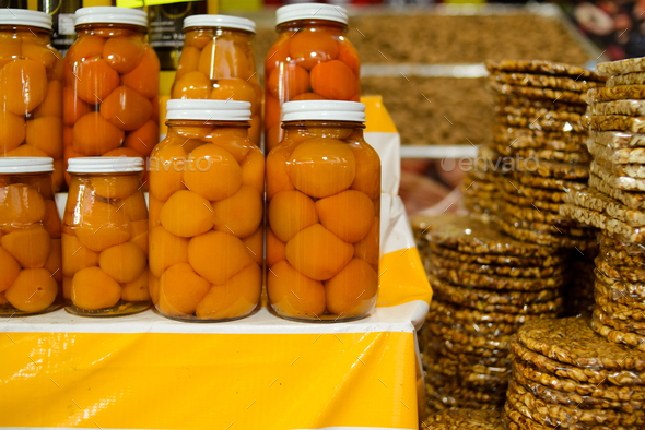 Jars with homemade peaches in syrup. Group of jars with peaches in ...