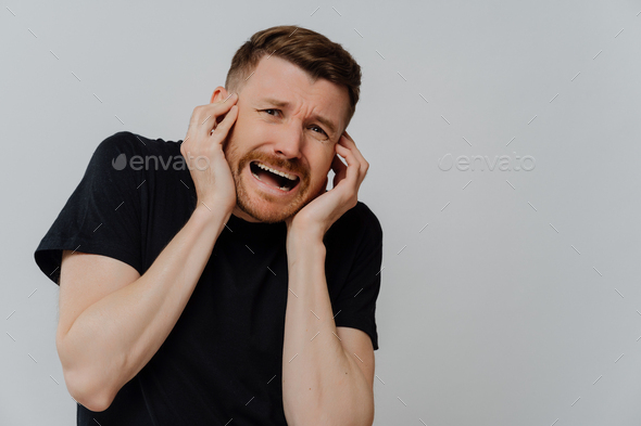 Scared man screaming while being afraid and looking with frightened ...