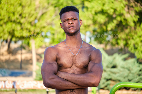 Portrait of young fit shirtless black man arms crossed outdoors. Stock ...