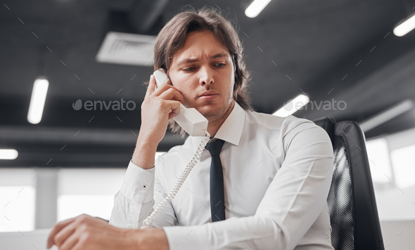 Serious businessman speaking on telephone in office Stock Photo by kegfire