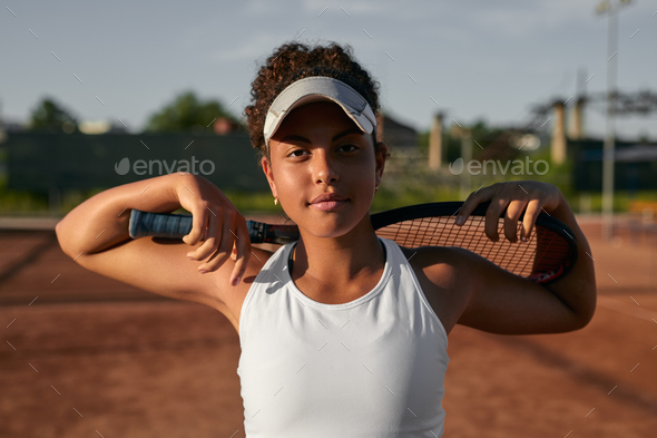 Black female tennis player with racket on court Stock Photo by kegfire
