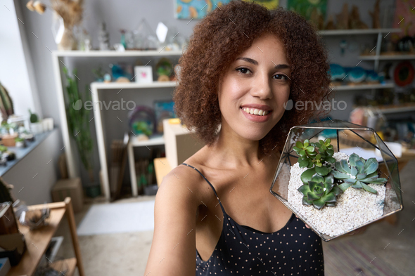 Talented female florist holding a glass container with succulents Stock ...