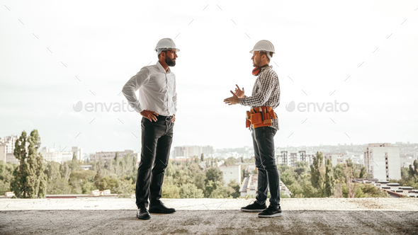 Foreman and engineer discussing project on construction site Stock ...