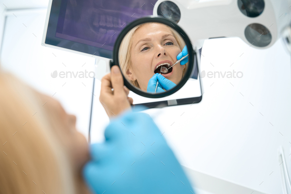 Beautiful lady is receiving professional teeth treatment in dental ...