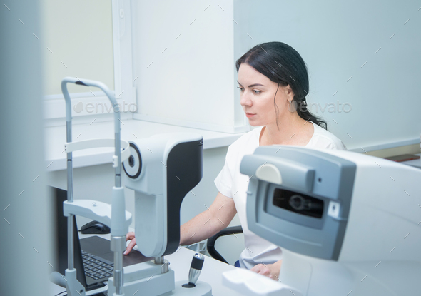 an optometrist at the vision testing devices, at the computer Stock ...