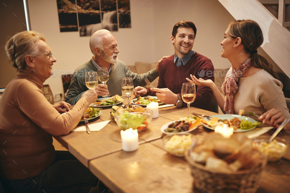 Happy family communicating while eating dinner at dining table. Stock ...