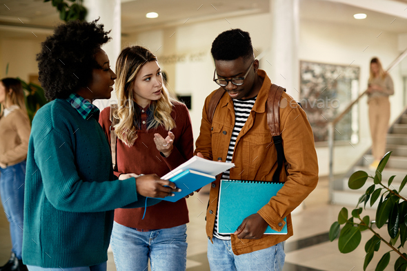 Group of college friends talking while going through lecture in a ...