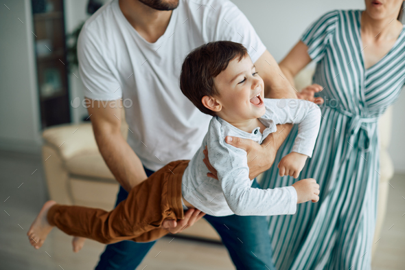Carefree boy having fun with his playful parents at home. Stock Photo ...