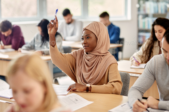 Muslim university student raising her hand to answer a question ...