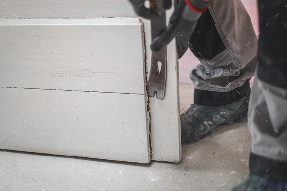 Hands of a man working with a crowbar indoors. Stock Photo by NataKor5