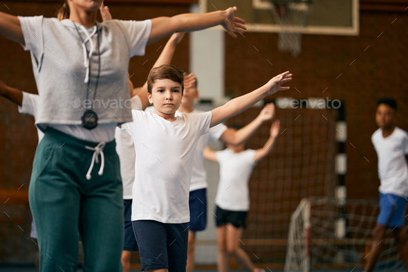 Elementary student and his friends warming up while having physical ...