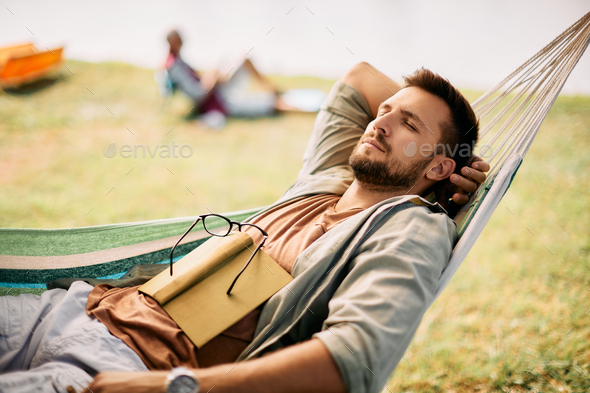 Relaxed man napping in hammock while spending a day in nature. Stock ...