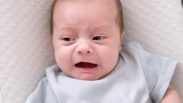 Dissatisfied Crying Upset Sad Newborn Baby Boy Lying in Nursery Cocoon ...