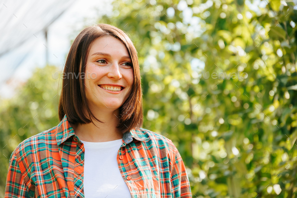 Front view portrait beautiful young woman farmer stand in garden smile ...