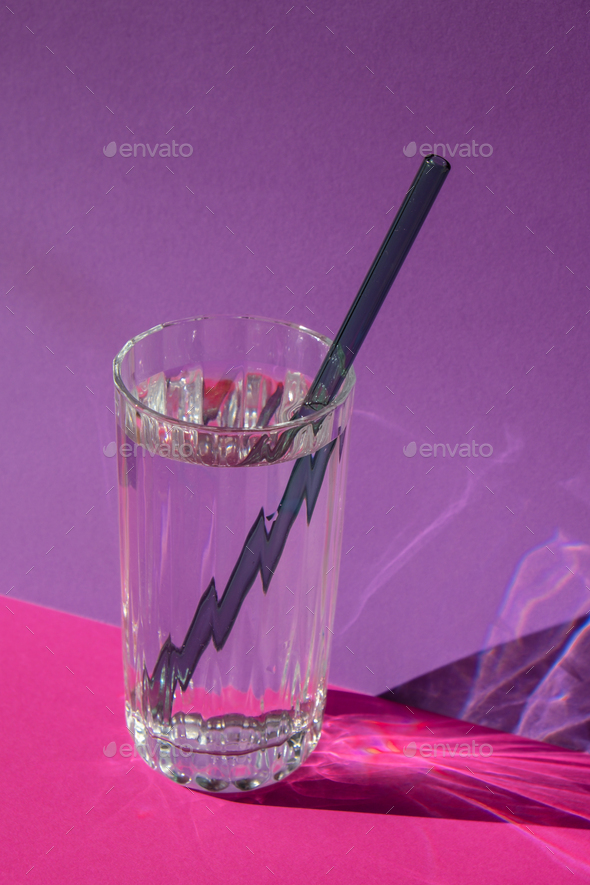 Reusable glass Straws in Glass with water on purple violet background ...