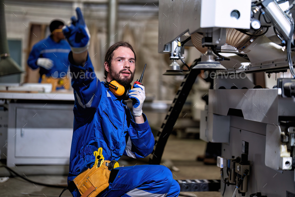 In wooden industrial engineer stand at circular saw machine controller ...