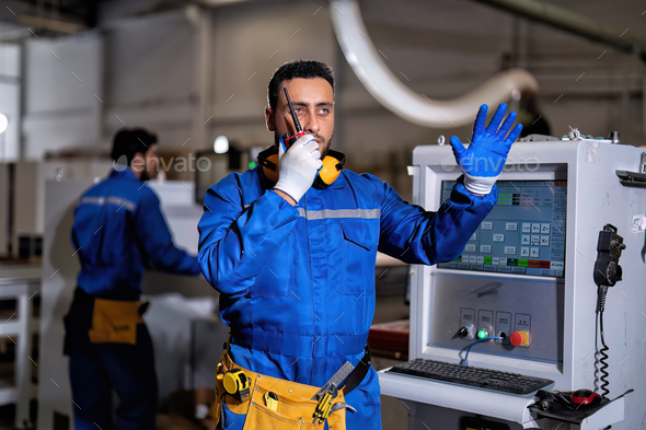 In wooden industrial engineer stand at circular saw machine controller ...