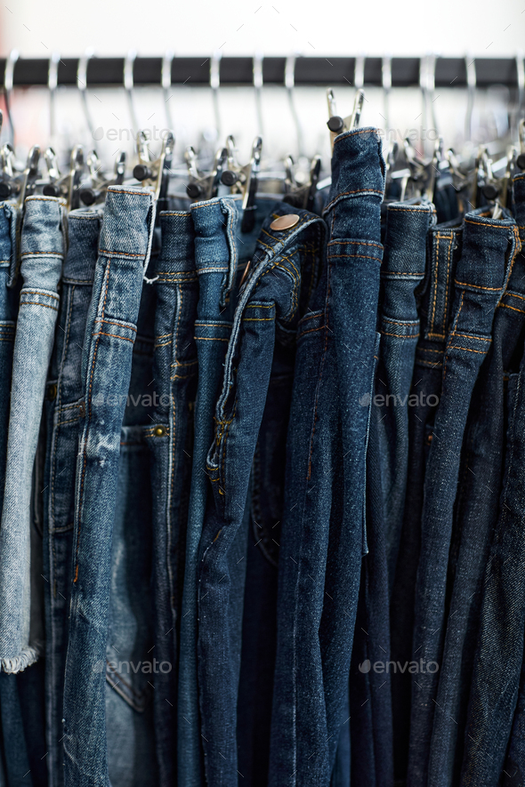 Blue denim jeans in row on clothing rack Stock Photo by seventyfourimages
