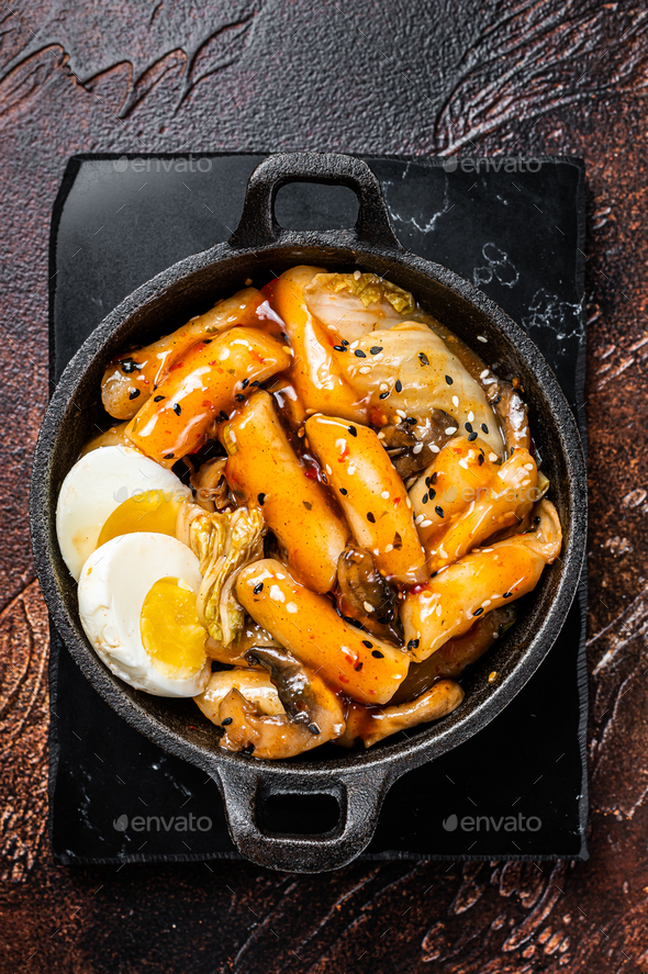 Korean Topokki or Tteokbokki rice cake with egg and mashrooms. Dark ...