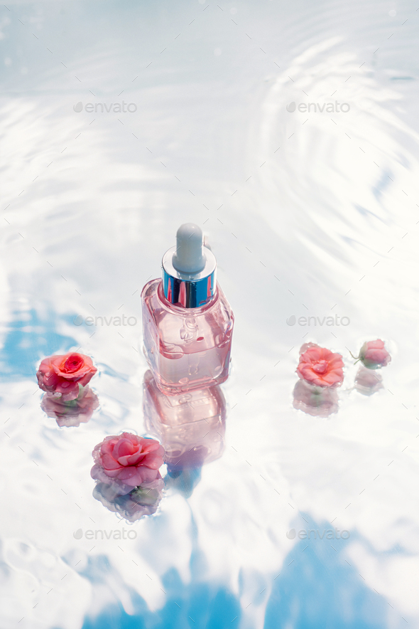 Transparent bottle on the surface of blue water with ripples and ...