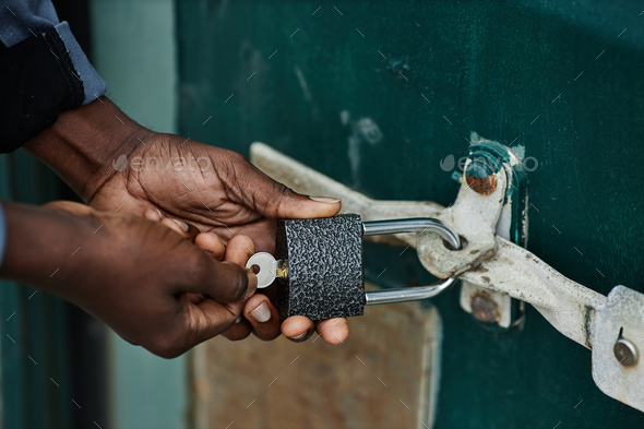 Close up of male hands opening lock Stock Photo by seventyfourimages