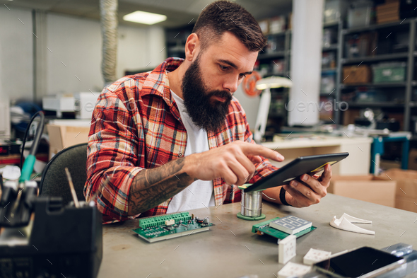 Electronics engineer working in a workshop with tin soldering parts and ...