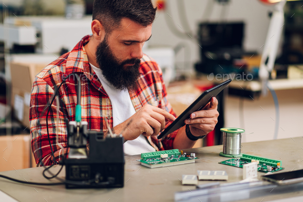 Electronics engineer working in a workshop with tablet Stock Photo by ...