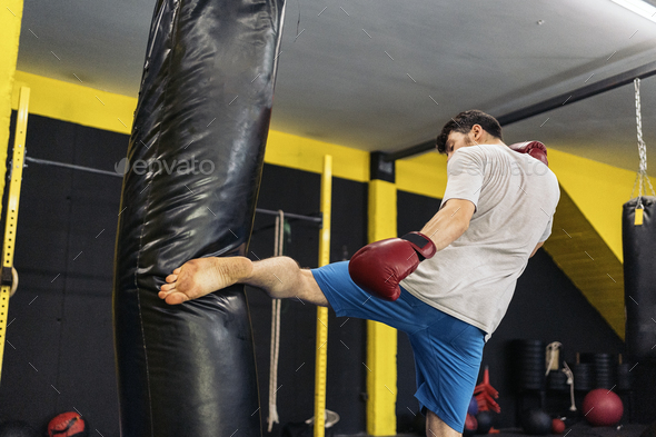 Kickboxing fighter performing Kicks with foot on punching bag at the ...