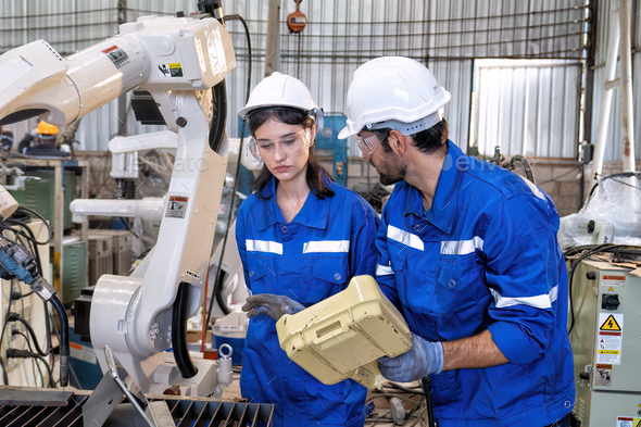 In robotic training center instructor teaching girl engineer how to operate and program robot ...