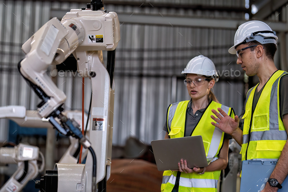 In robotic training instructor teach girl engineer to program robot arm ...