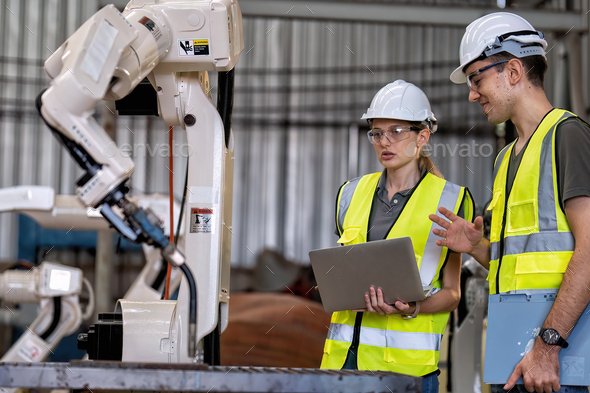 In robotic training instructor teach girl engineer to program robot arm ...