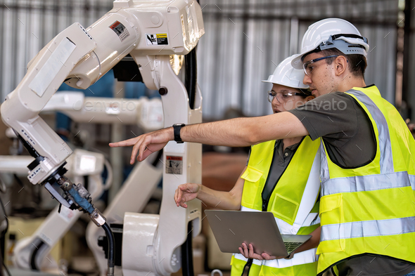 In robotic training instructor teach girl engineer to program robot arm ...