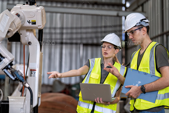 In robotic training instructor teach girl engineer to program robot arm ...