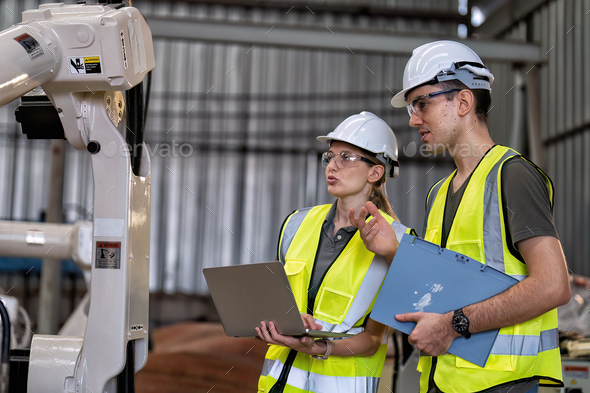 In robotic training instructor teach girl engineer to program robot arm ...