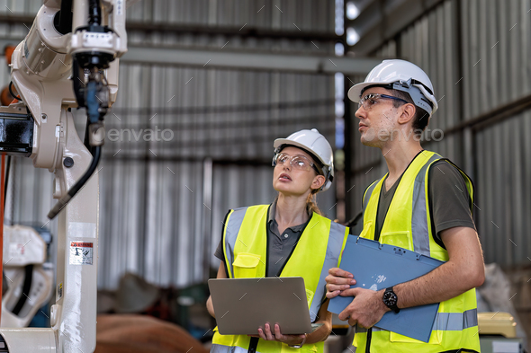 In robotic training instructor teach girl engineer to program robot arm ...