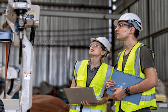 In robotic training instructor teach girl engineer to program robot arm ...