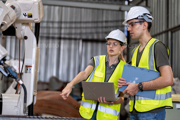 In robotic training instructor teach girl engineer to program robot arm ...