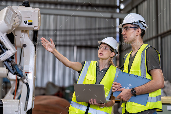 In robotic training instructor teach girl engineer to program robot arm ...