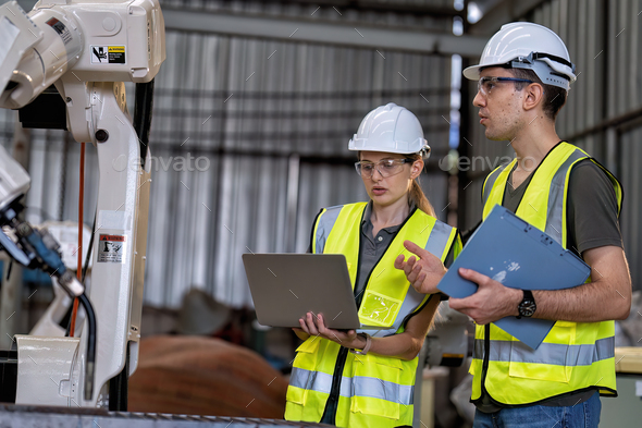 In robotic training instructor teach girl engineer to program robot arm ...