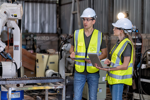 In robotic training instructor teach girl engineer to program robot arm ...