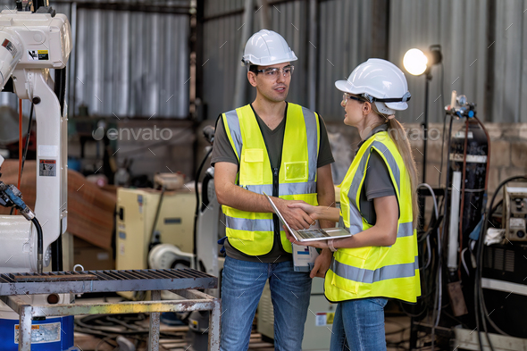 In robotic training instructor teach girl engineer to program robot arm ...