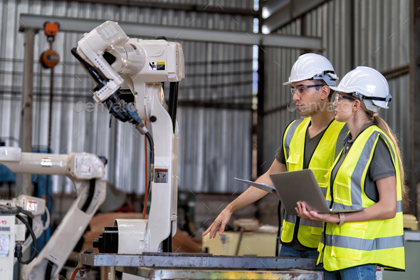 In robotic training instructor teach girl engineer to program robot arm ...