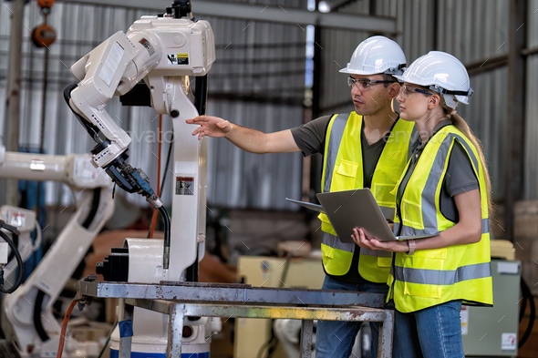 In robotic training instructor teach girl engineer to program robot arm ...
