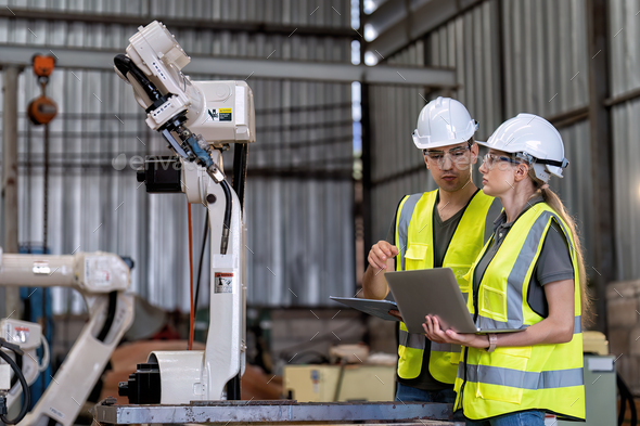 In robotic training instructor teach girl engineer to program robot arm ...
