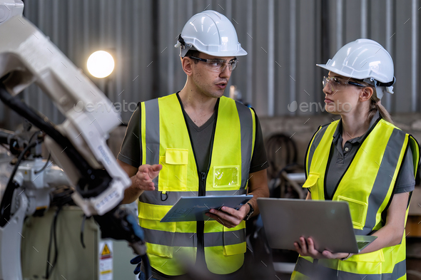 In robotic training instructor teach girl engineer to program robot arm ...