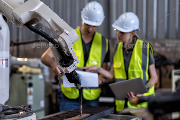 In robotic training instructor teach girl engineer to program robot arm ...