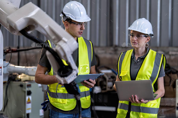 In robotic training instructor teach girl engineer to program robot arm ...